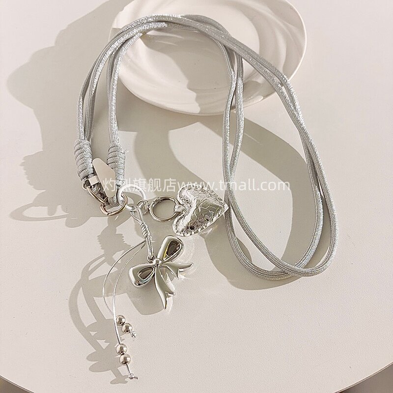 高级感轻奢银皮革爱心蝴蝶结套装手机挂件尼龙线材斜跨长绳户外手机链通用ccd相机侧肩背带便携挂链百搭女款