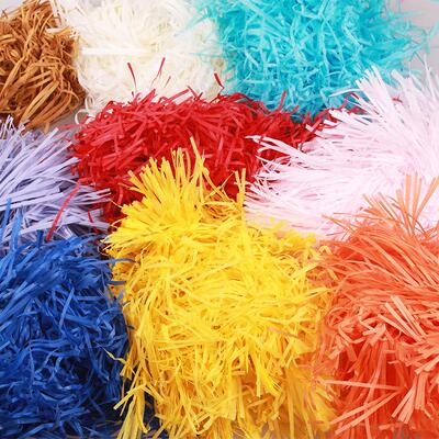 gift lined with shredded paper filling colored packing box