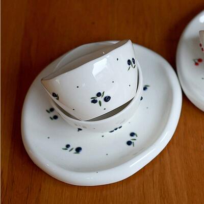 Cherry patterned ceramic tea cups, dessert bowls, and plates