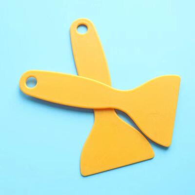 A small cleaning spatula that doesn't damage floors or glass